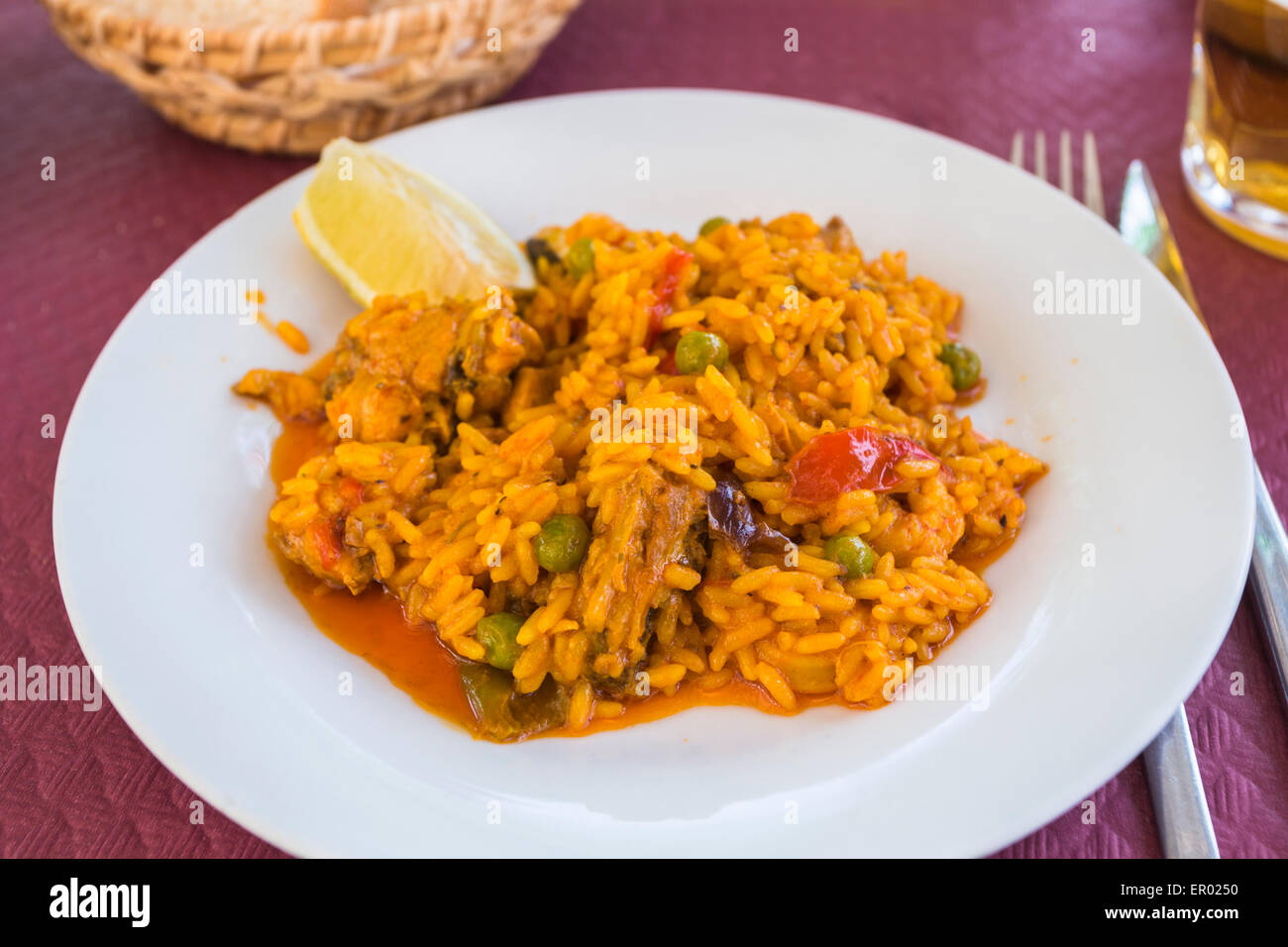 Plate of delicious yellow saffron coloured mixed paella served on a ...