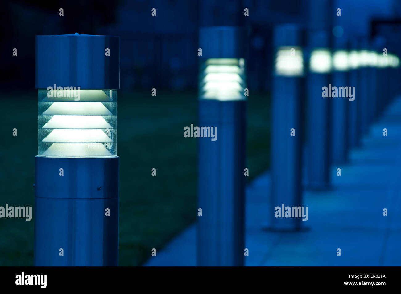 Row of lamp posts along walkway at business park Stock Photo - Alamy