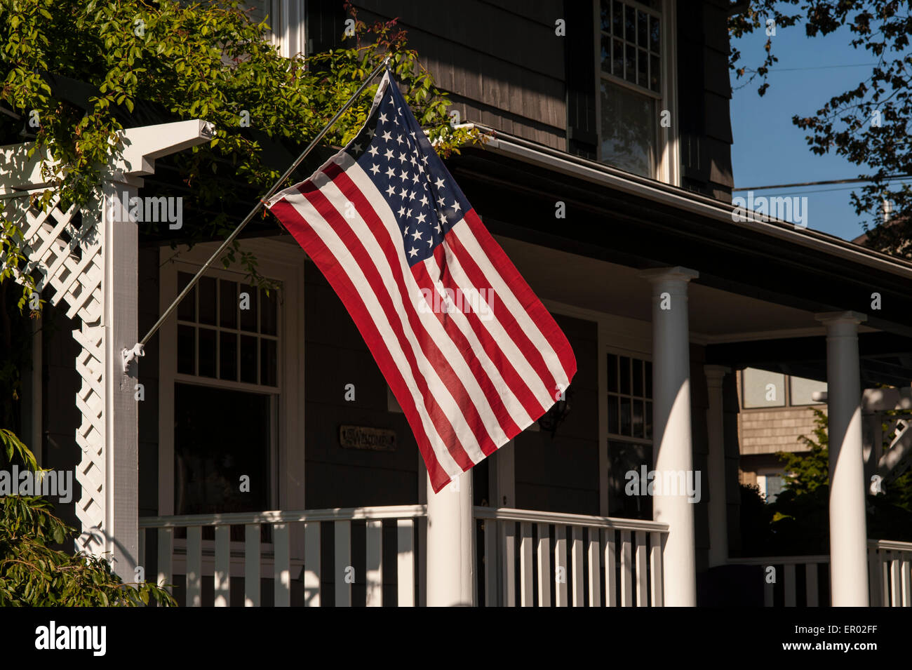 Home with American Flag on porch with yard and ideal neigborhood rural ...