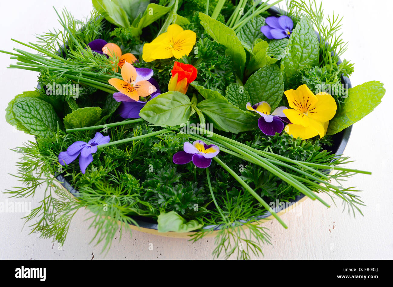 Cooking with herbs concept with fresh herbs and edible flowers in ...