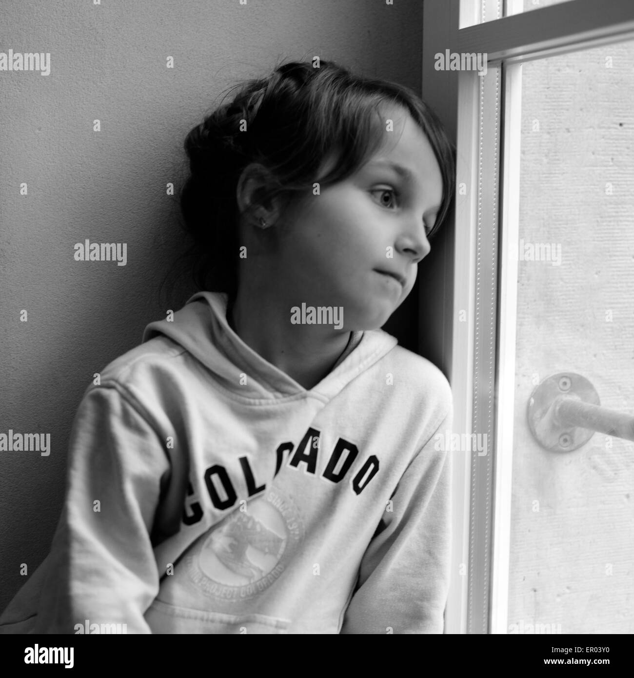 girl looking sadly through a window Stock Photo - Alamy