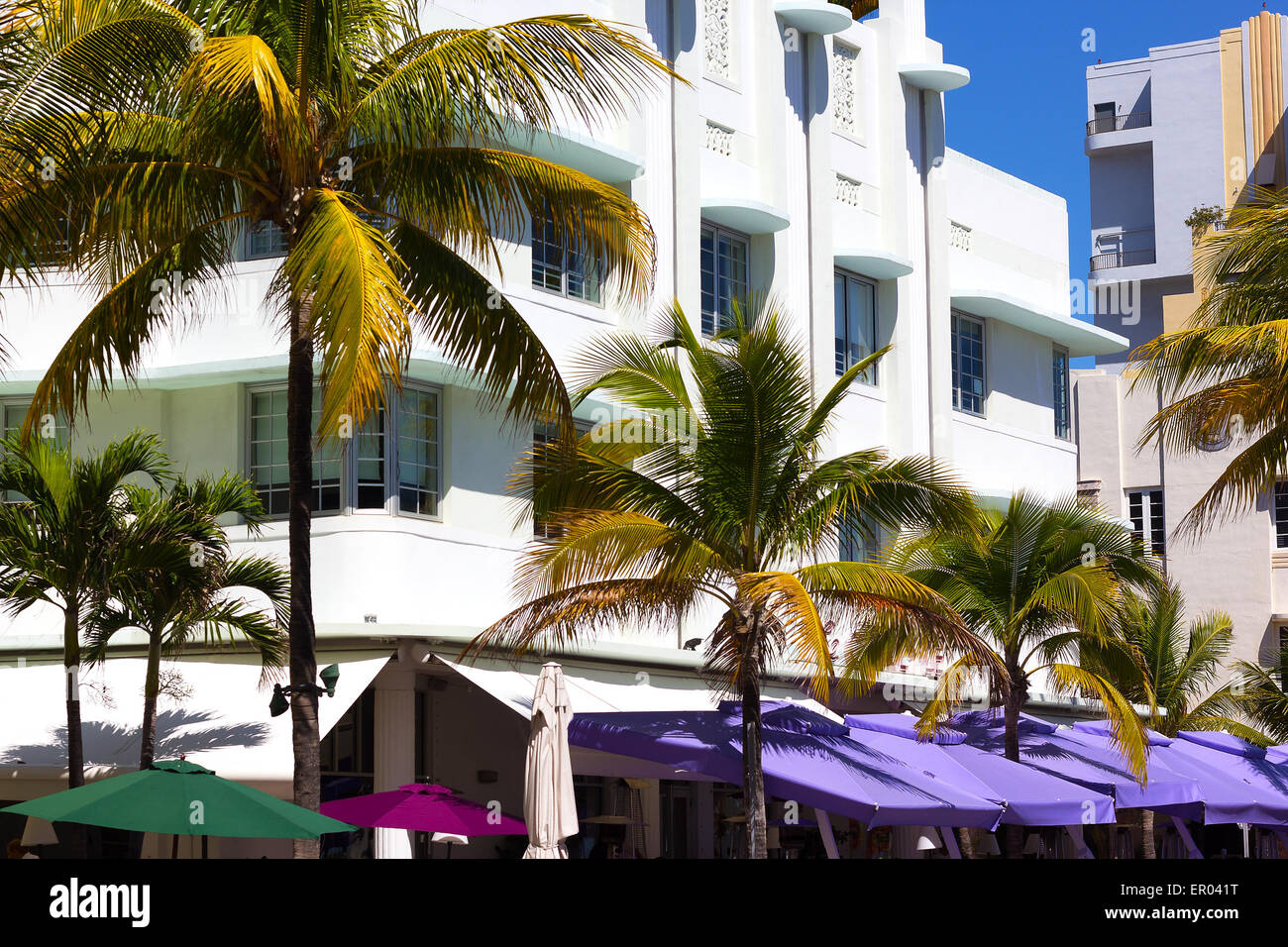 A building on the street with palms and colorful umbrellas Stock Photo ...