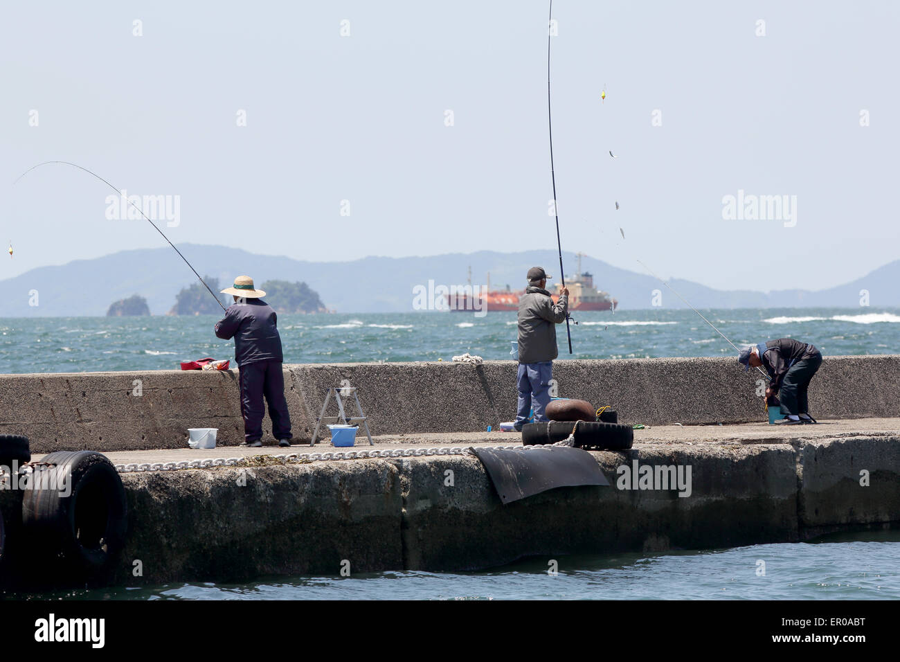 Men fishing off the pier Stock Photo - Alamy