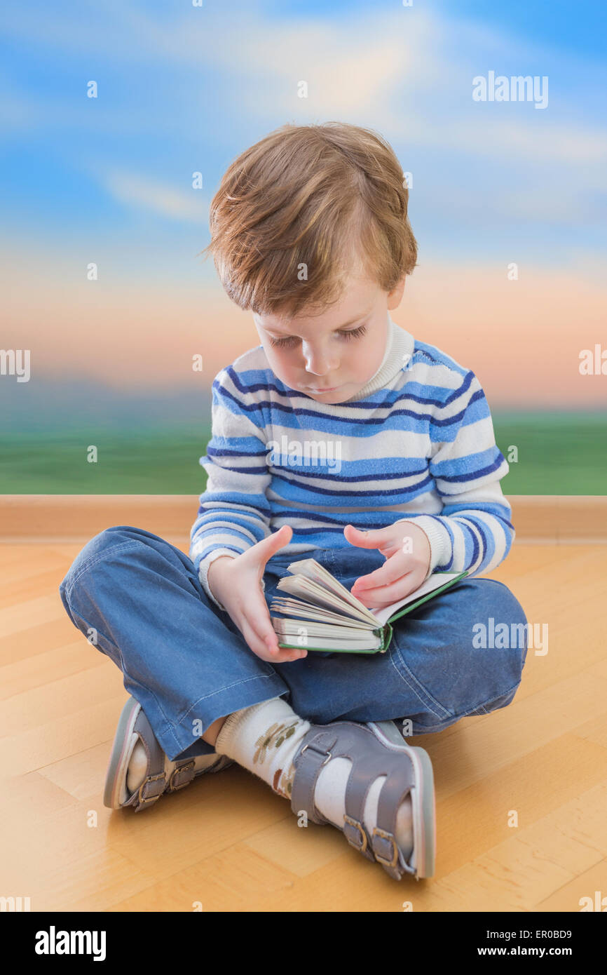Boy reading book seating on the floor and sunrise background Stock ...