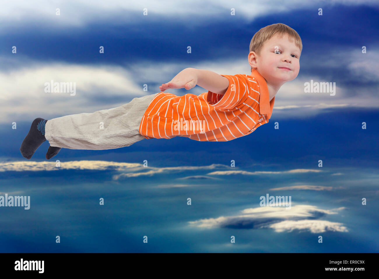 Young boy flying cloud sky in background Stock Photo - Alamy