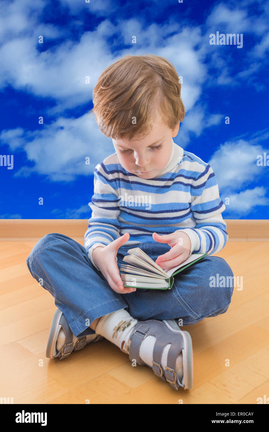 Boy reading book seating on the floor and cloud sky in background Stock ...