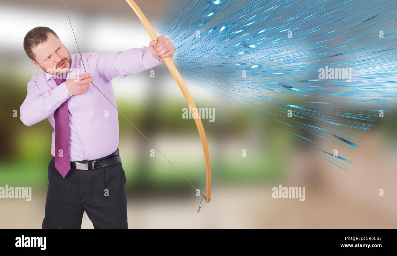 Businessman practicing archery and modern office interior in background ...