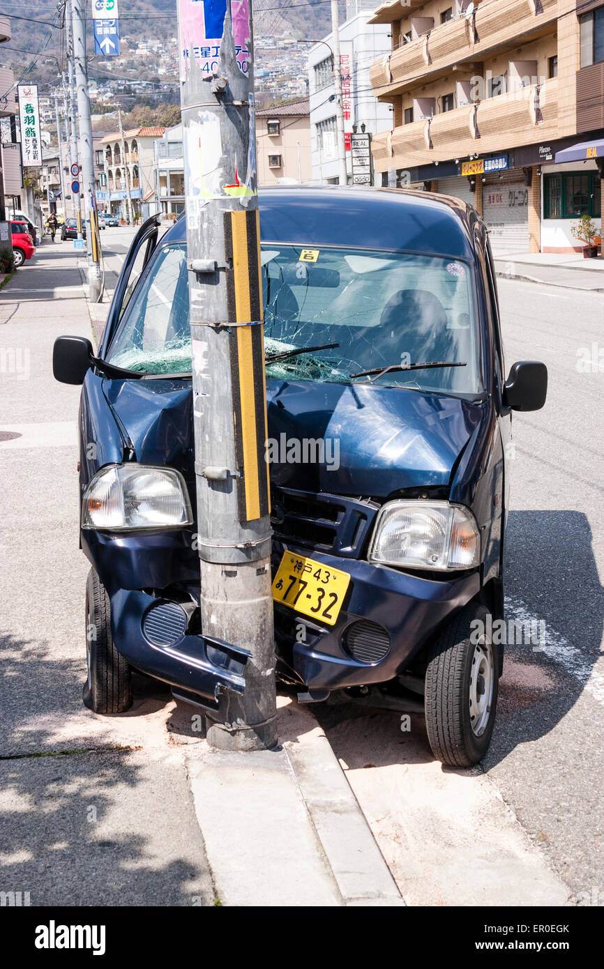 Car accident. Blue small car crashed into a street lamp post on a sunny ...