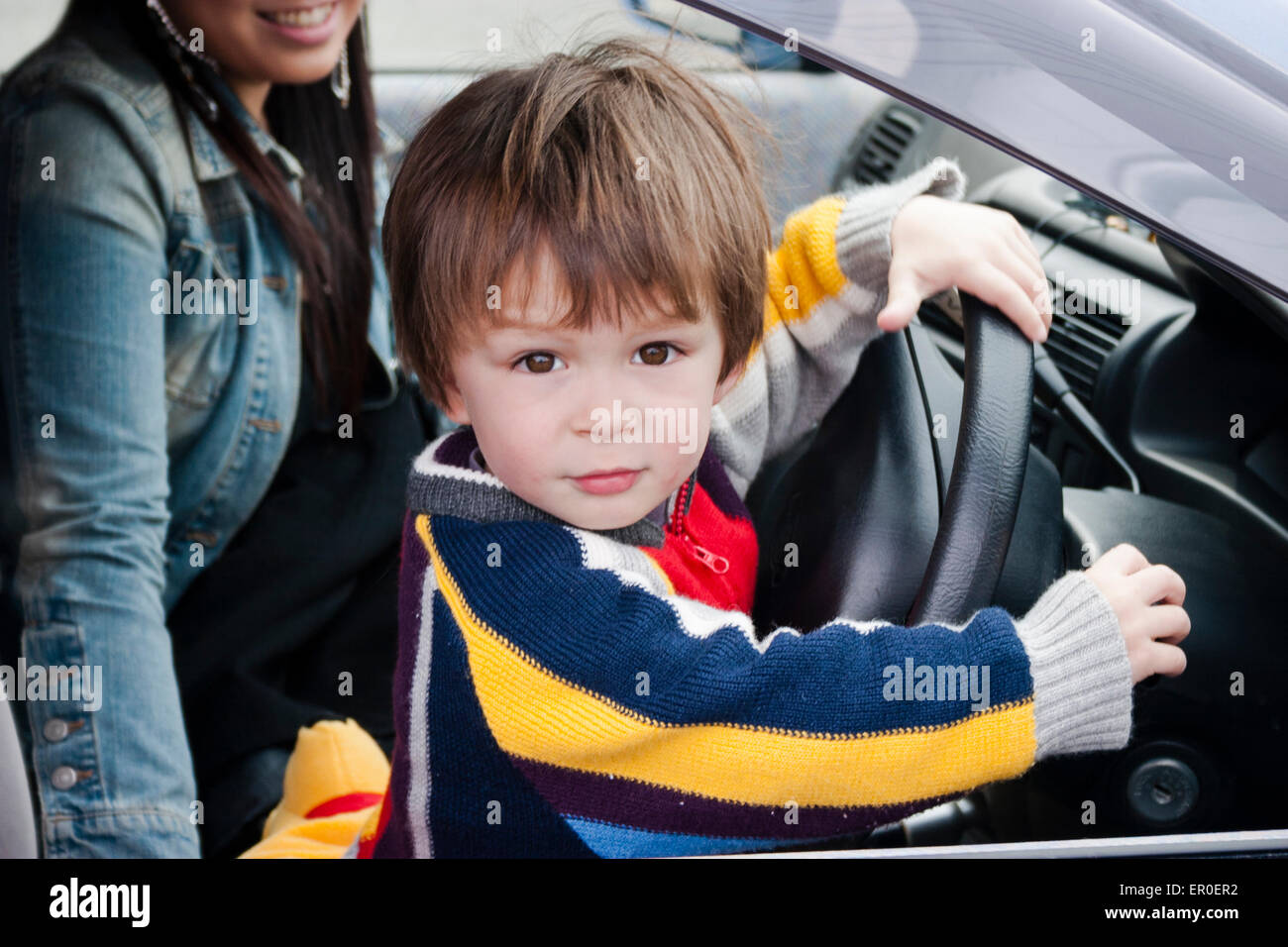 View through open car window of child, boy, 3-4 year old, holding ...