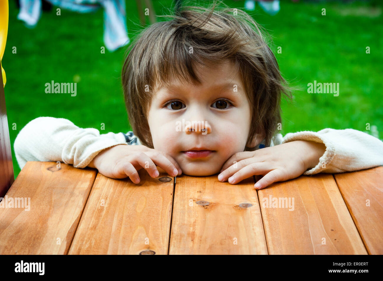 Close up of young child's face, boy, 3-4 year old, as he rests chin and ...