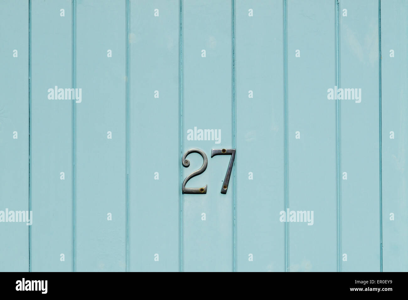 House number 27 twenety seven on a weathered blue painted metal door ...