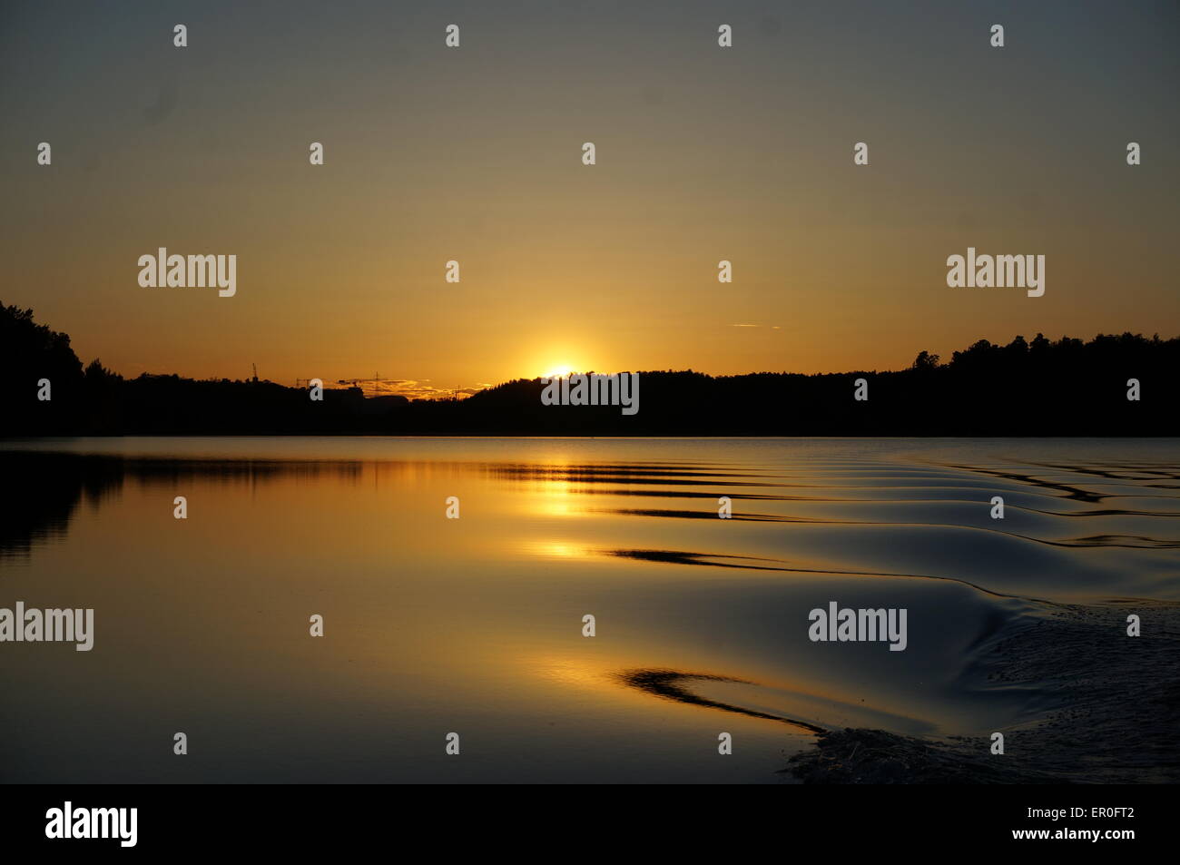 Sunset over calm water Stock Photo - Alamy