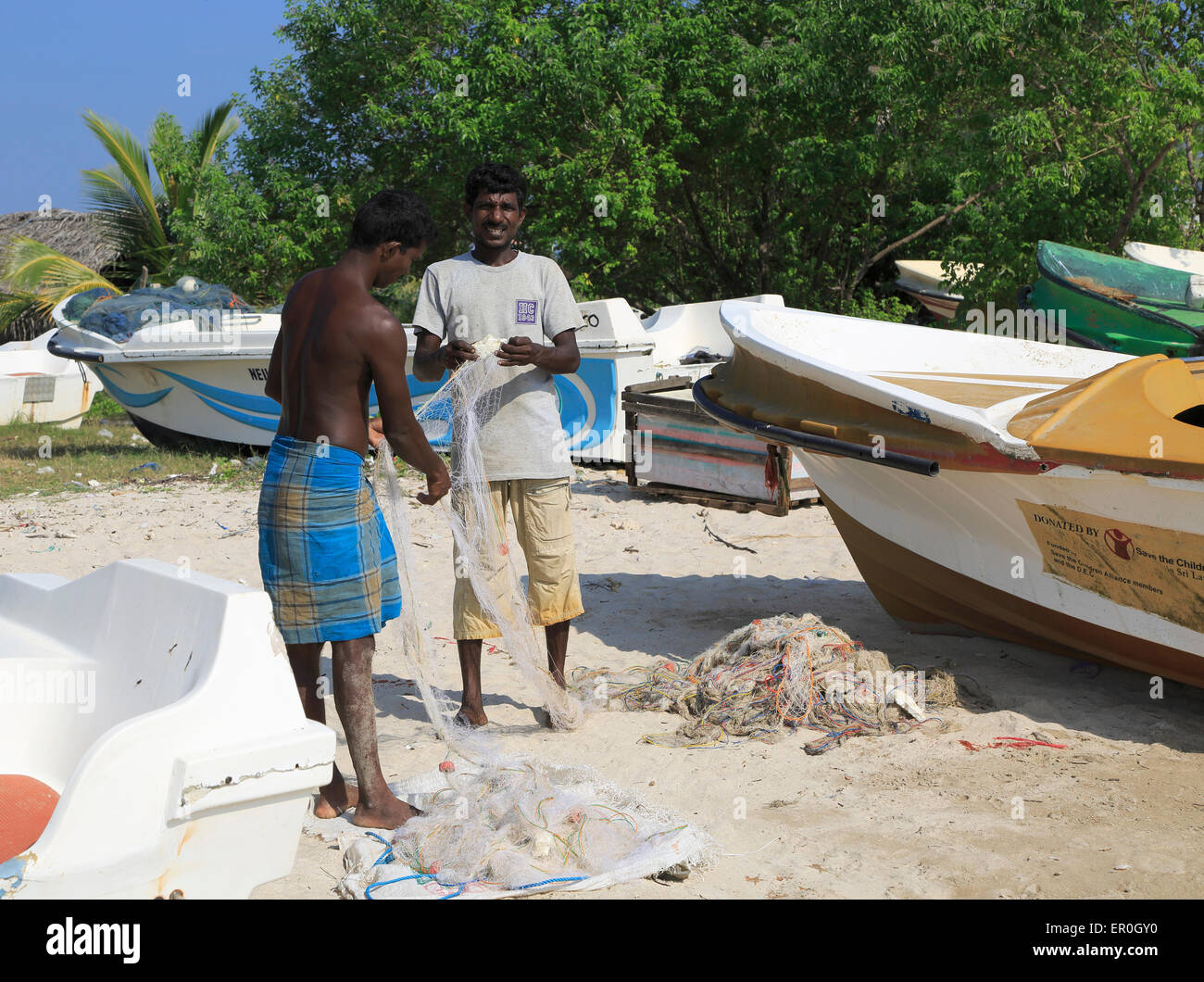 Men with fishing nets on tropical beach at Pasikudah Bay, Eastern ...