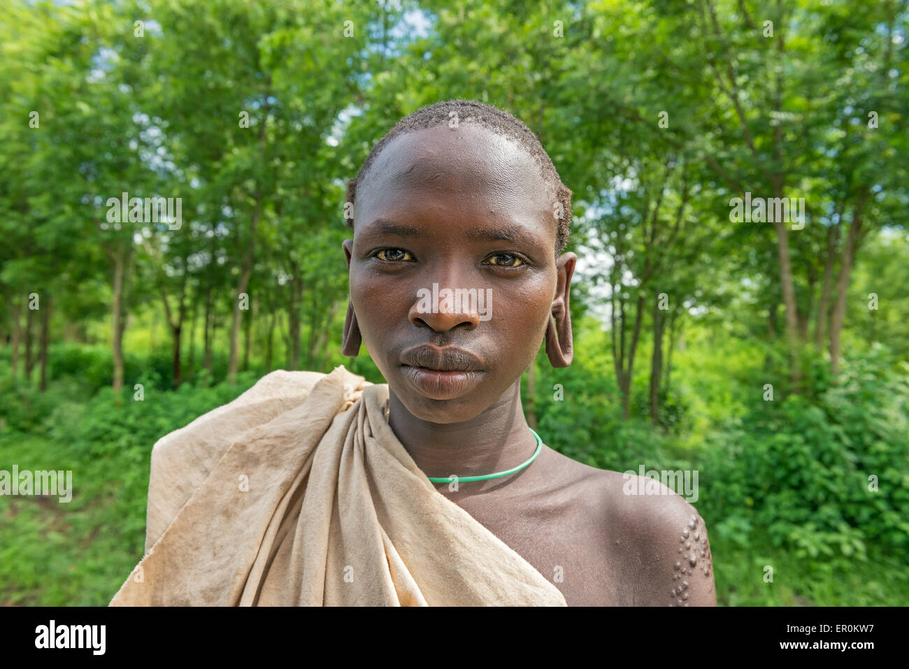 Portrait of a young boy from the african tribe Suri with traditionally ...