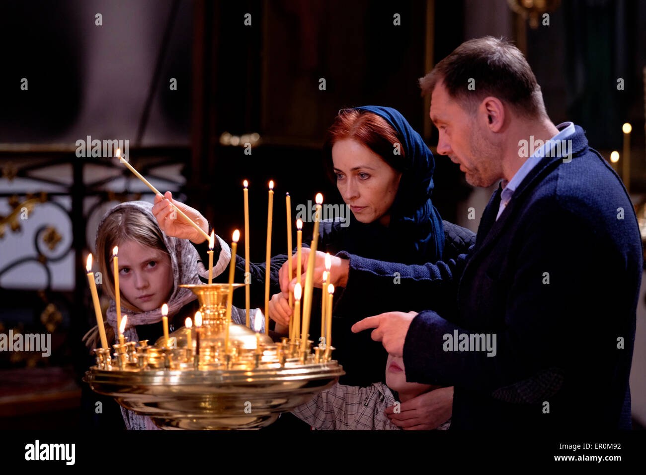 A Lithuanian family light candles in a church in the old town of ...
