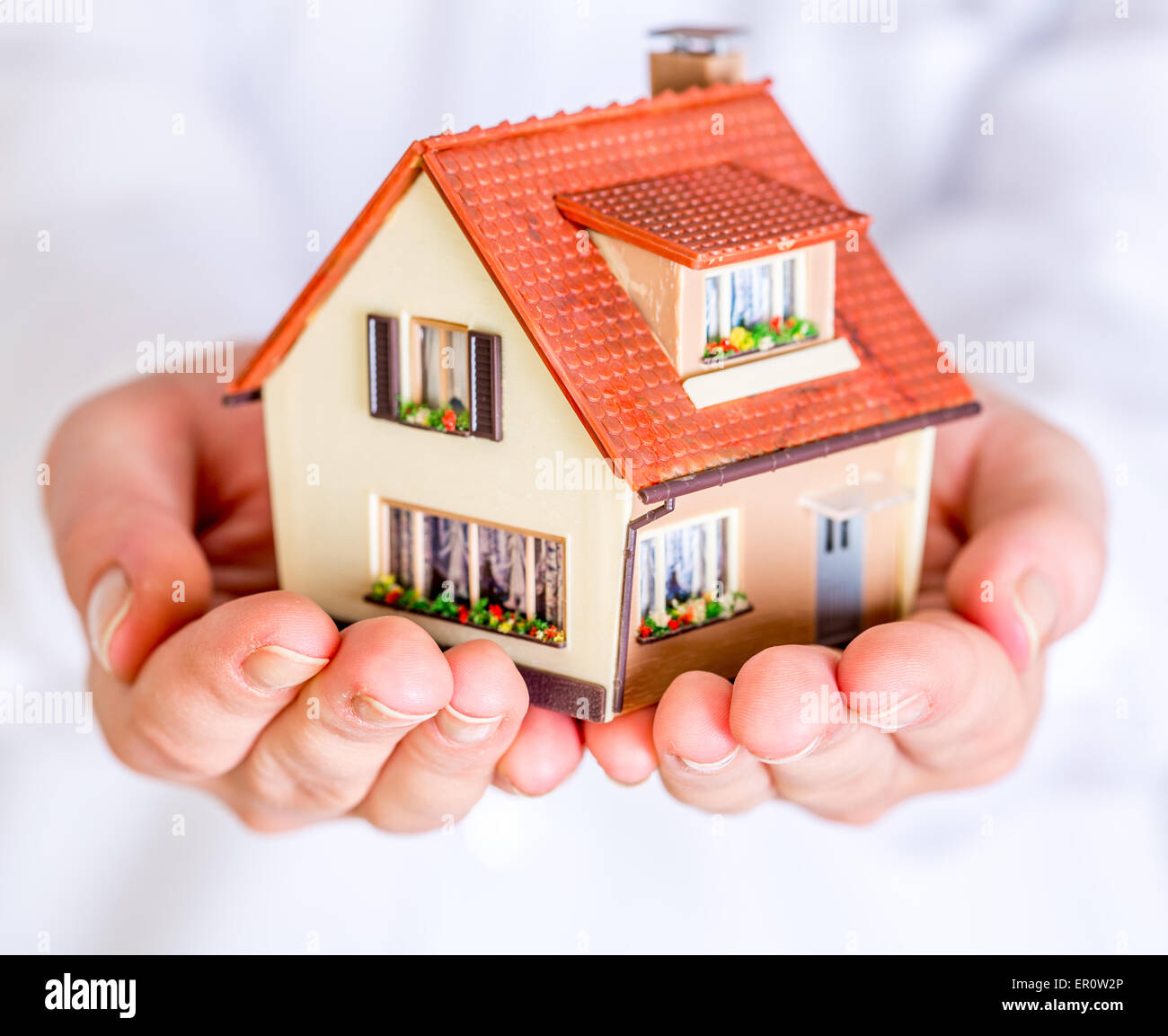 house in human hands on a white background Stock Photo - Alamy