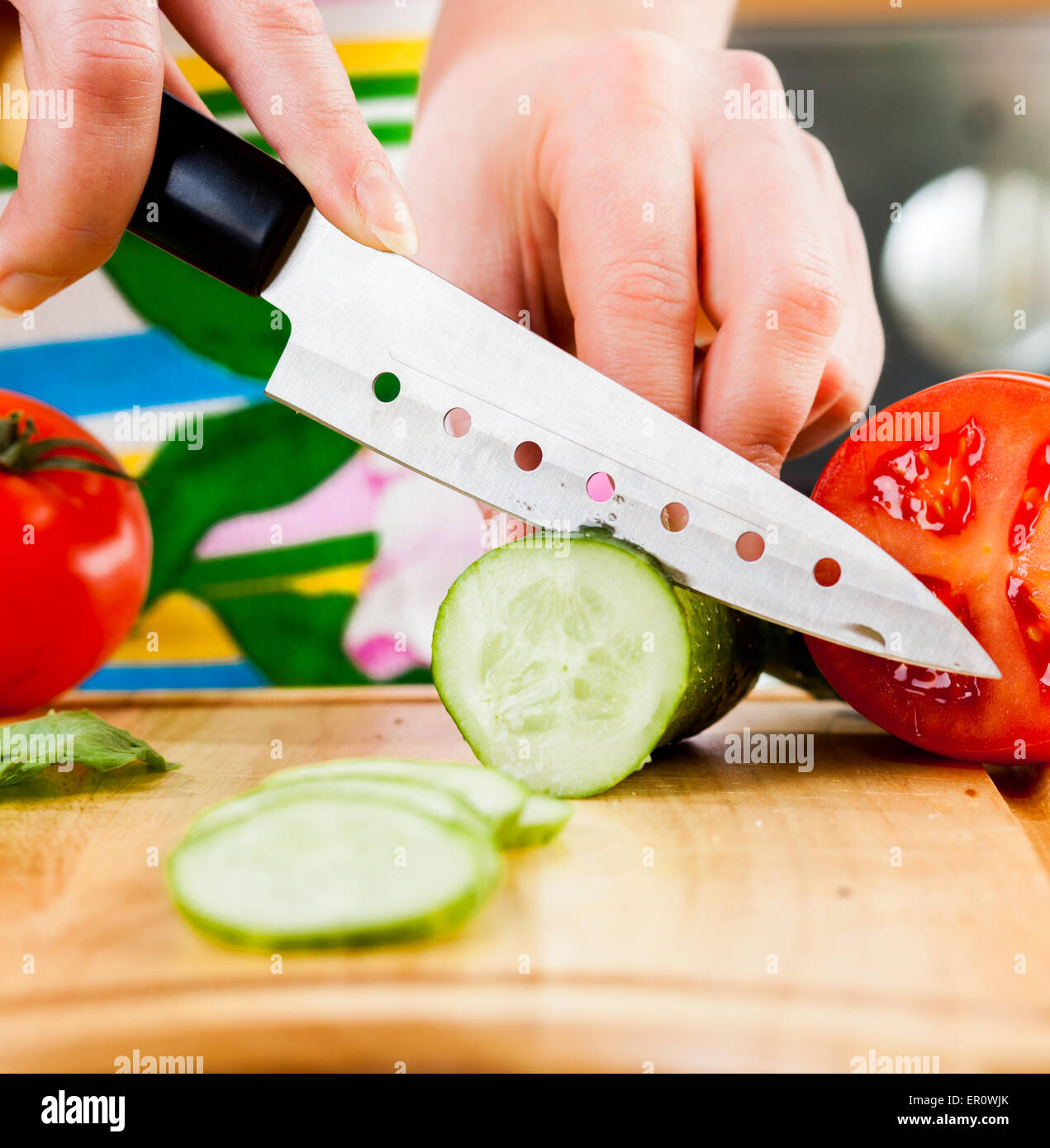 Woman's hands cutting cucumber, behind fresh vegetables Stock Photo - Alamy