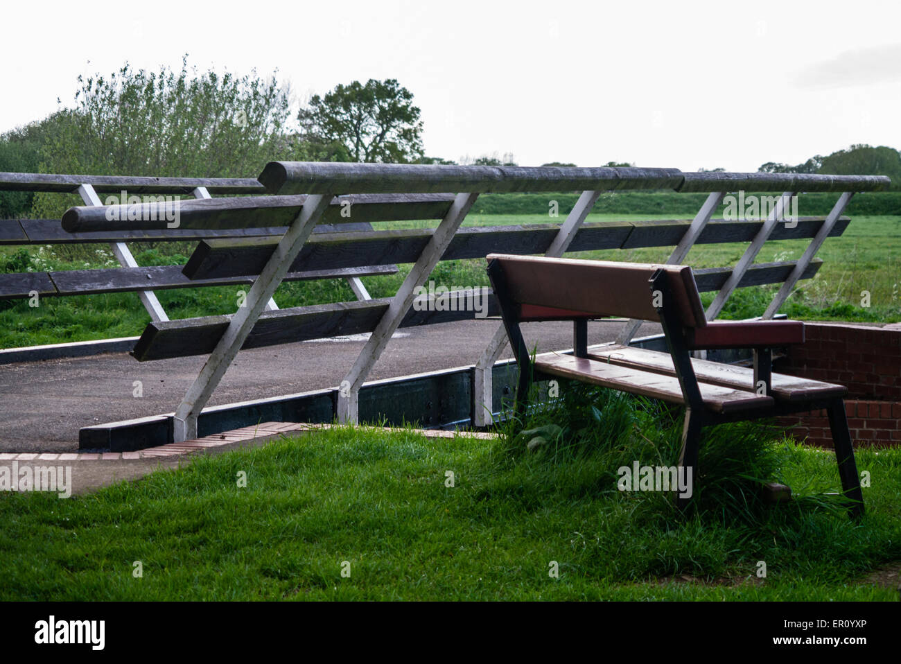 Bench alongside a swing bridge over a canal in a rural setting Stock ...
