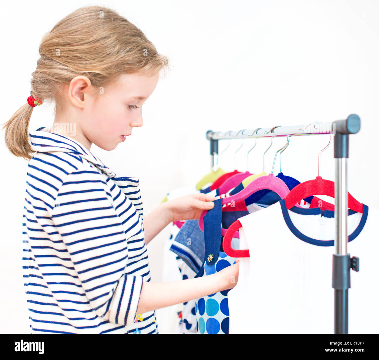 Little girl choosing dress in clothing store Stock Photo - Alamy