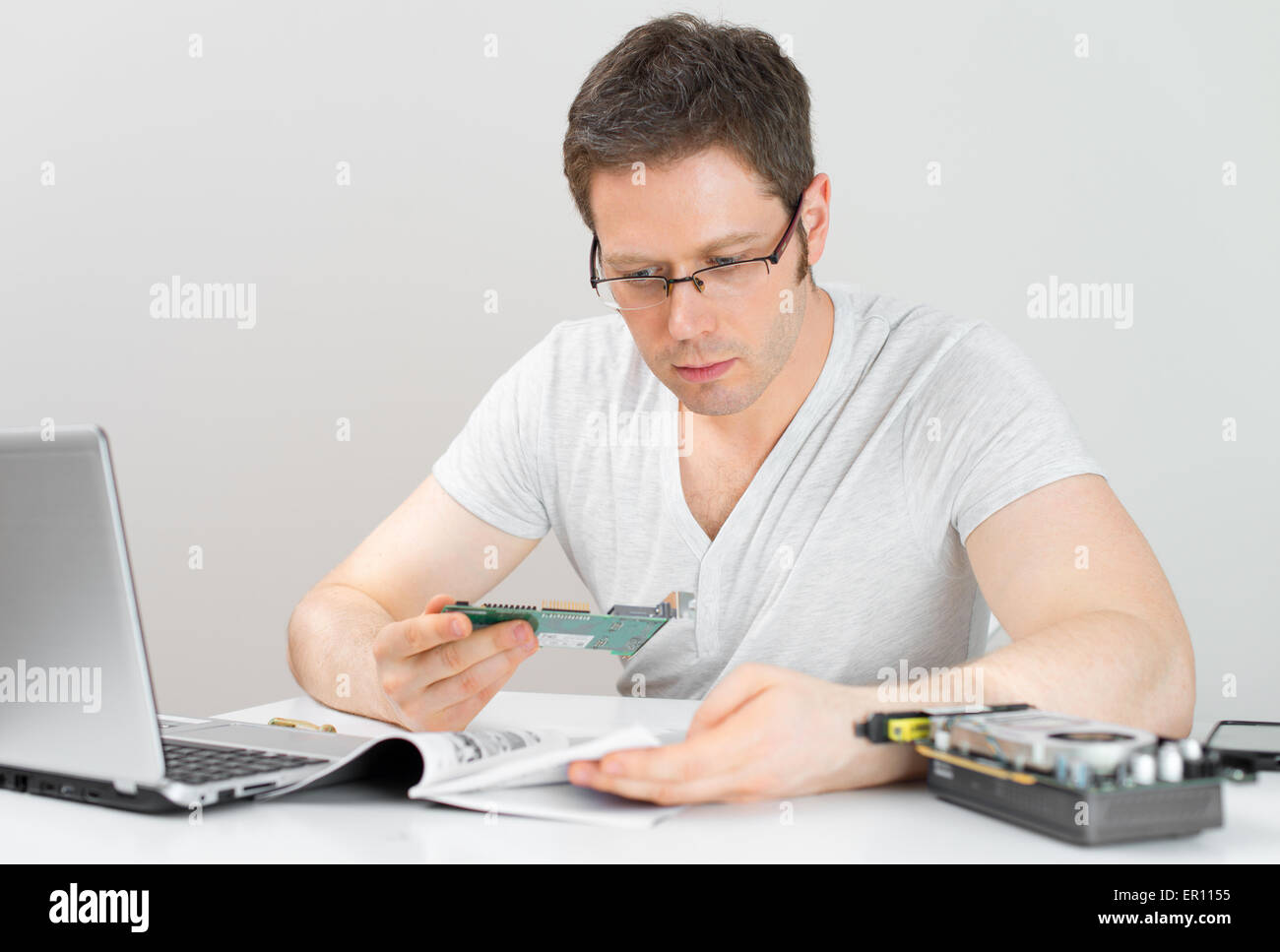 Male technician reading manual at his workplace Stock Photo - Alamy
