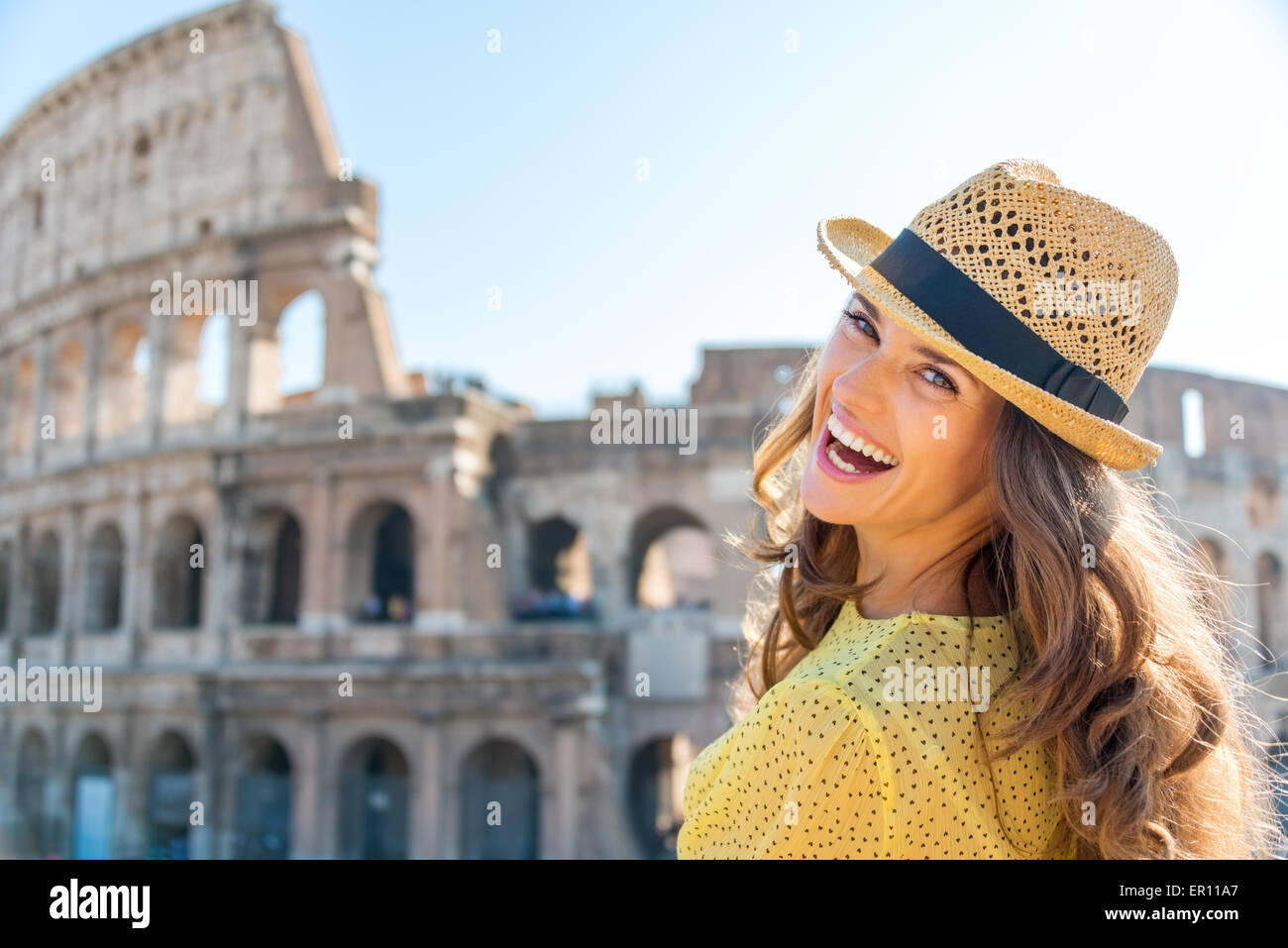 A woman is turning and looking over her shoulder while laughing ...