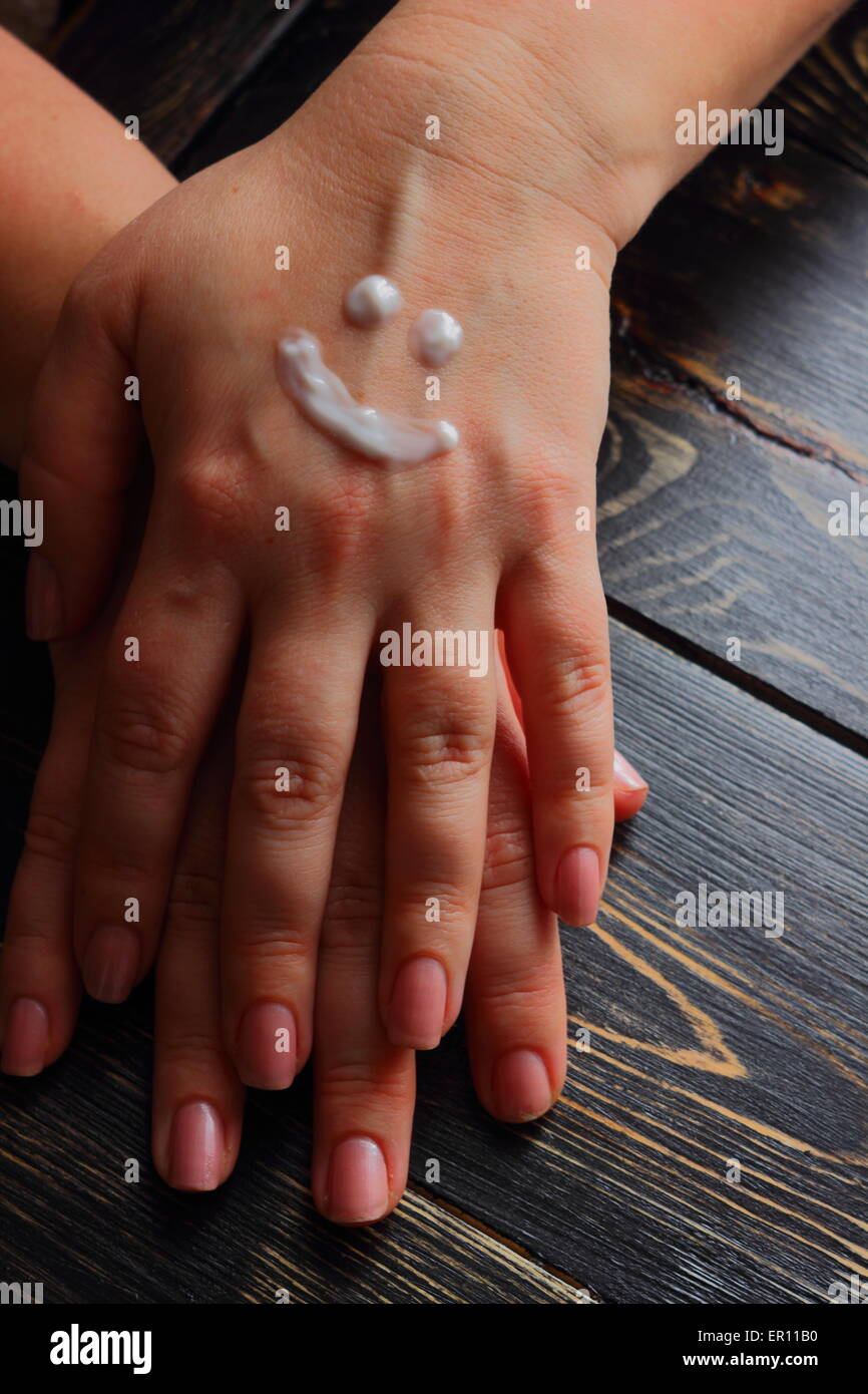 on the hand cream is applied smiley Stock Photo - Alamy