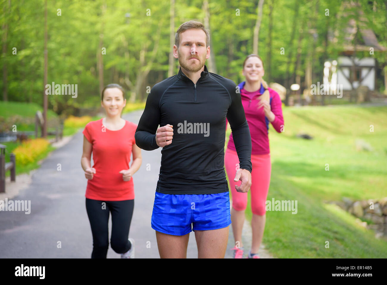 Smiling friends running outdoors Stock Photo - Alamy