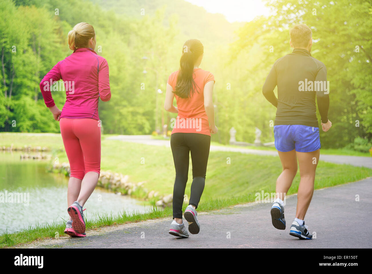 Smiling friends running outdoors Stock Photo - Alamy