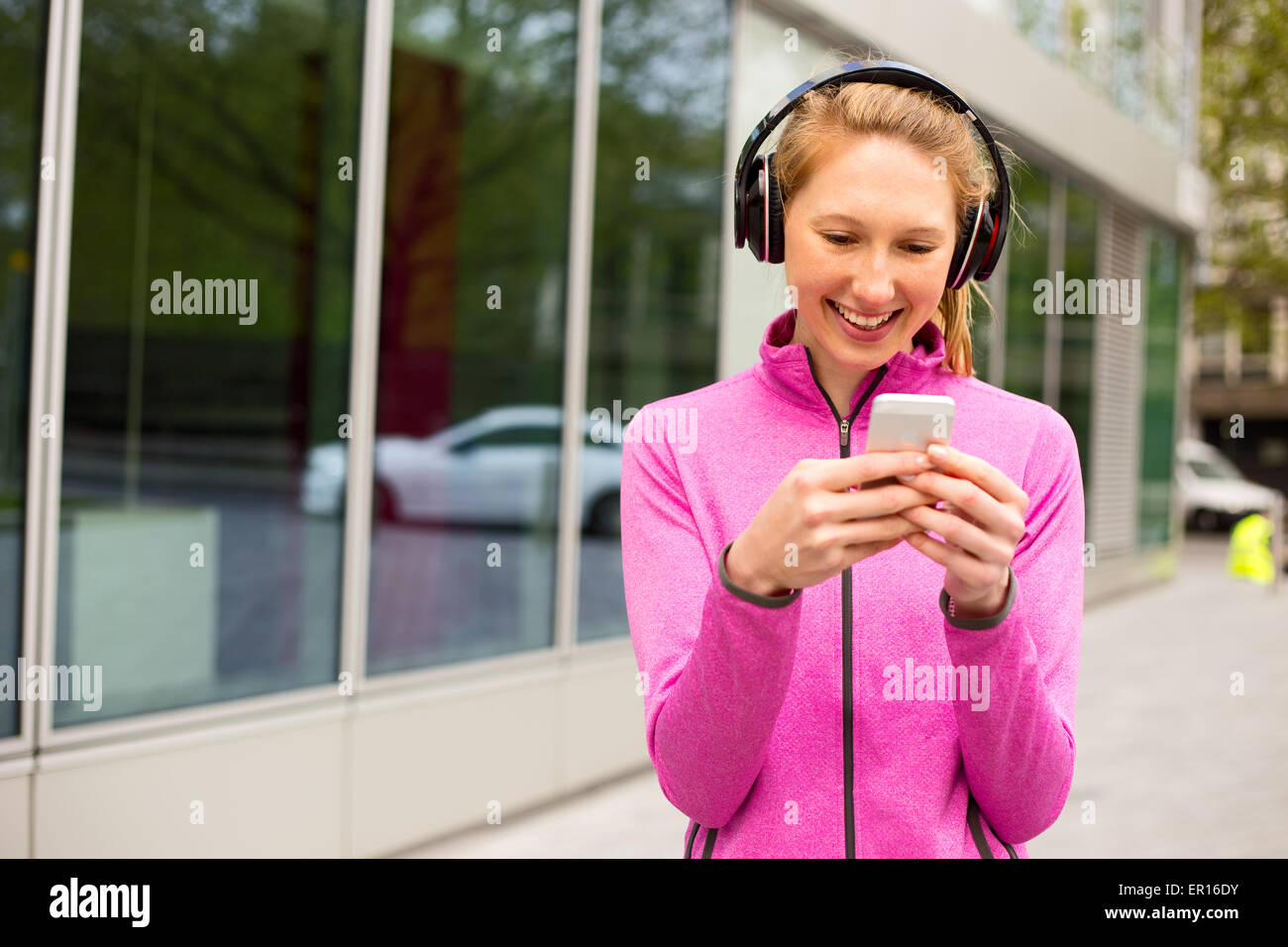 young woman wearing headphones and using her phone Stock Photo - Alamy