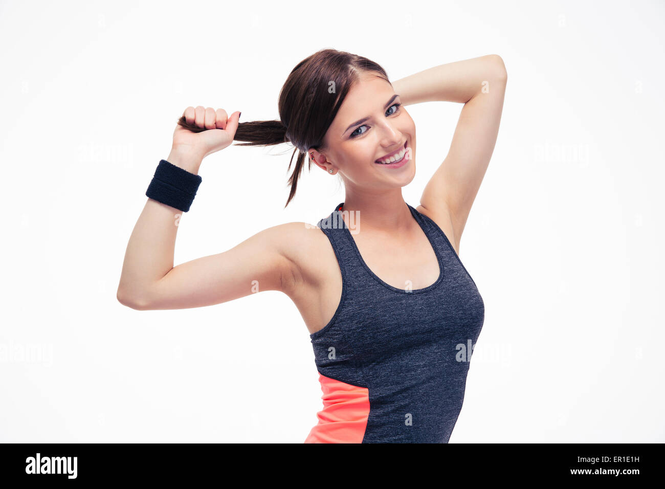 Smiling cute fitness woman holding her hair in ponytail isolated on a ...