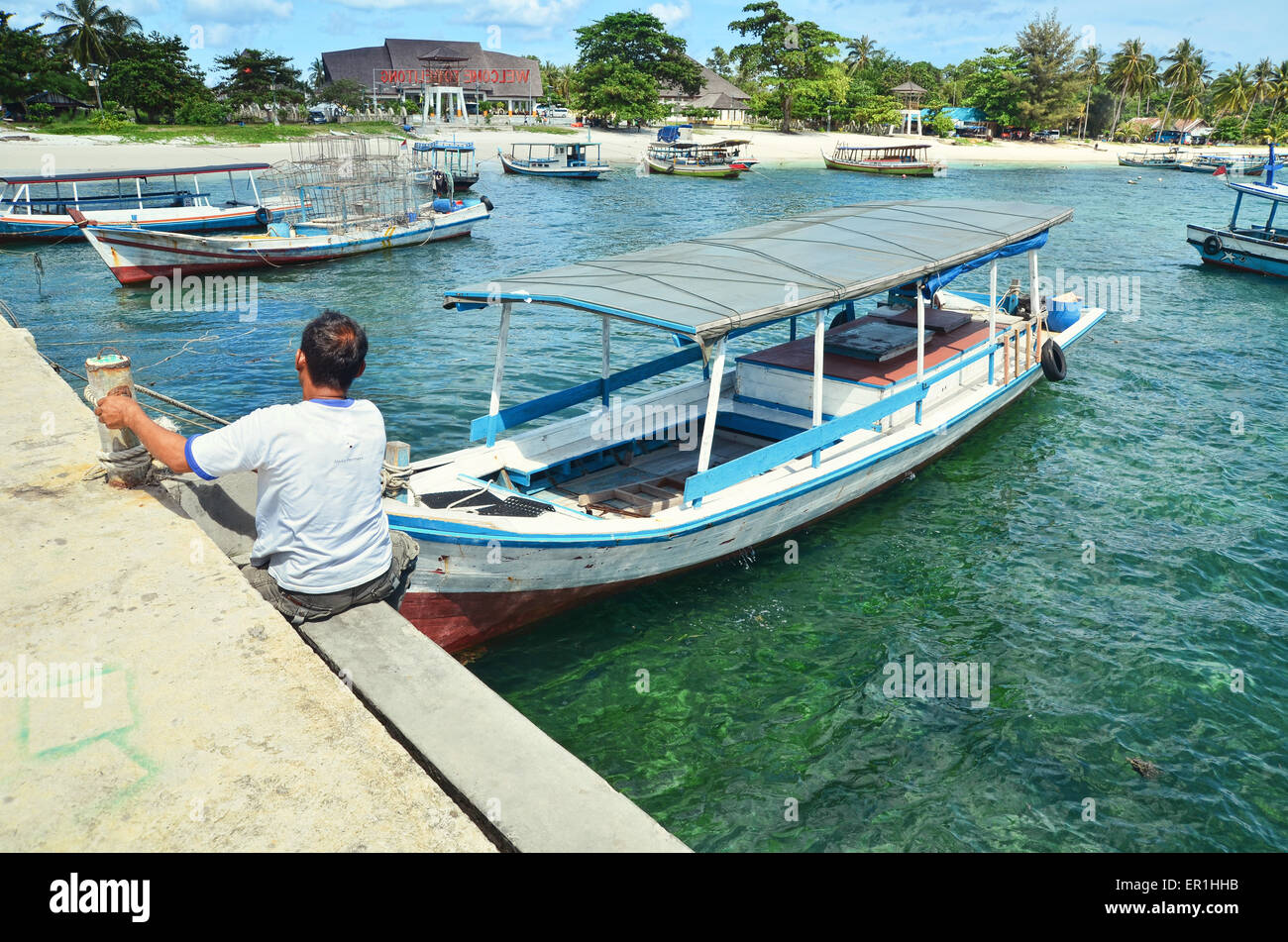 Fisherman moor his boat at the pier of Tanjung Kelayang Beach Stock ...