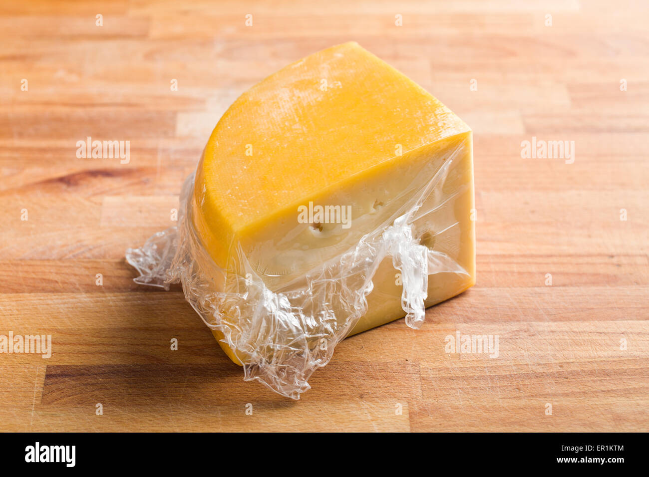 wrapped edam cheese on kitchen table Stock Photo - Alamy