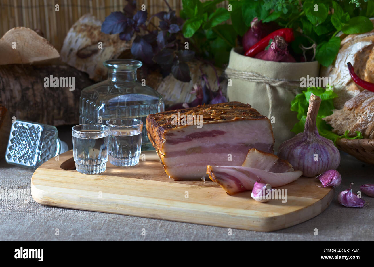 Vodka and smoked meat with garlic on kichen table Stock Photo - Alamy