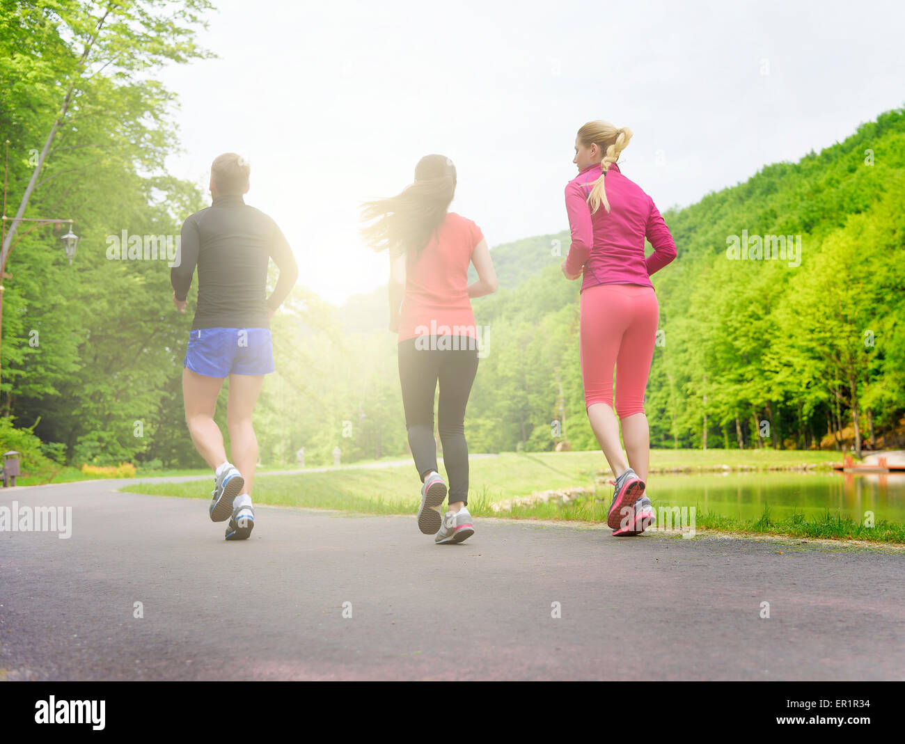 Smiling friends running outdoors Stock Photo - Alamy