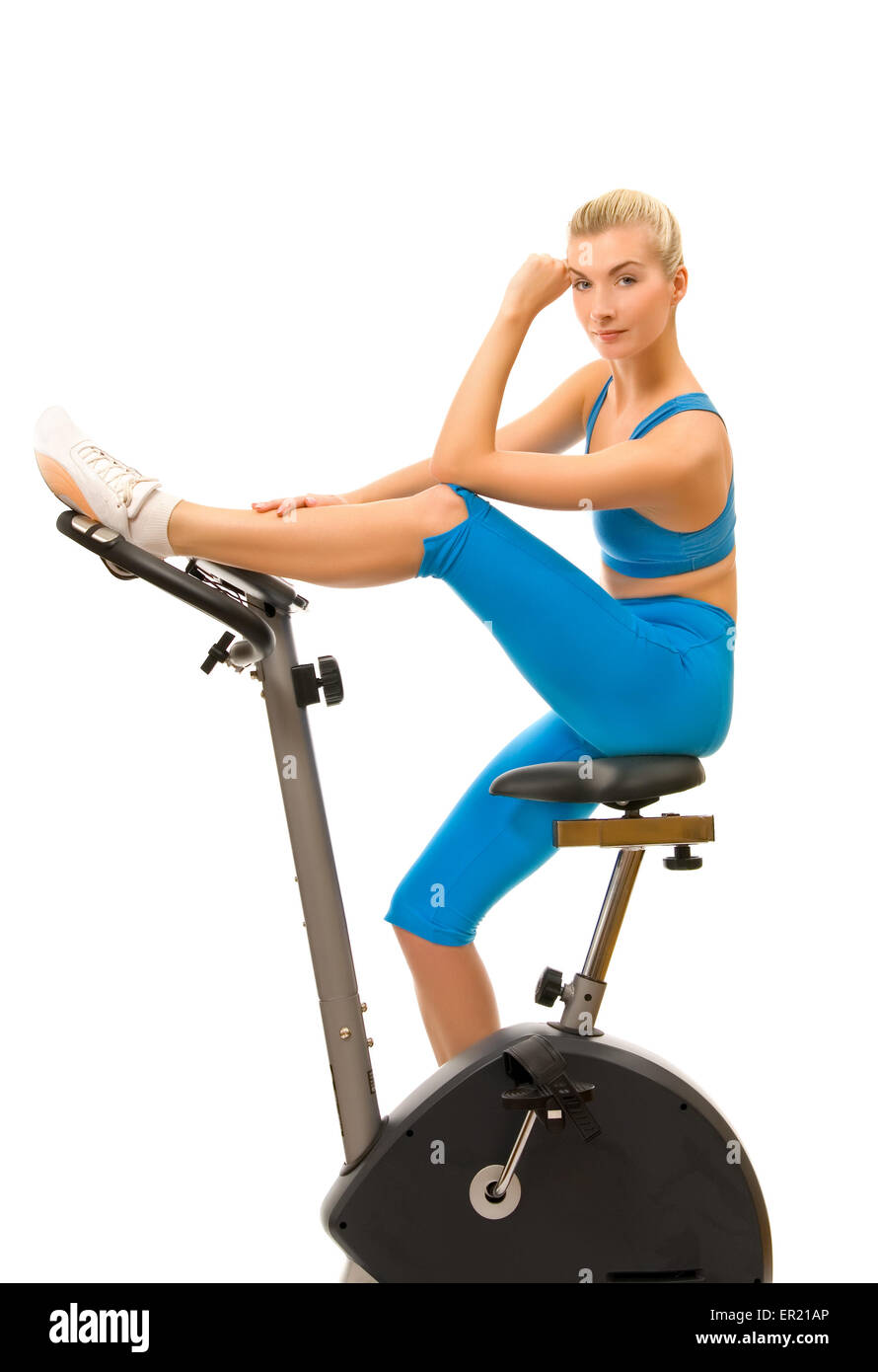 Beautiful young woman on exercise bicycle over white background Stock ...