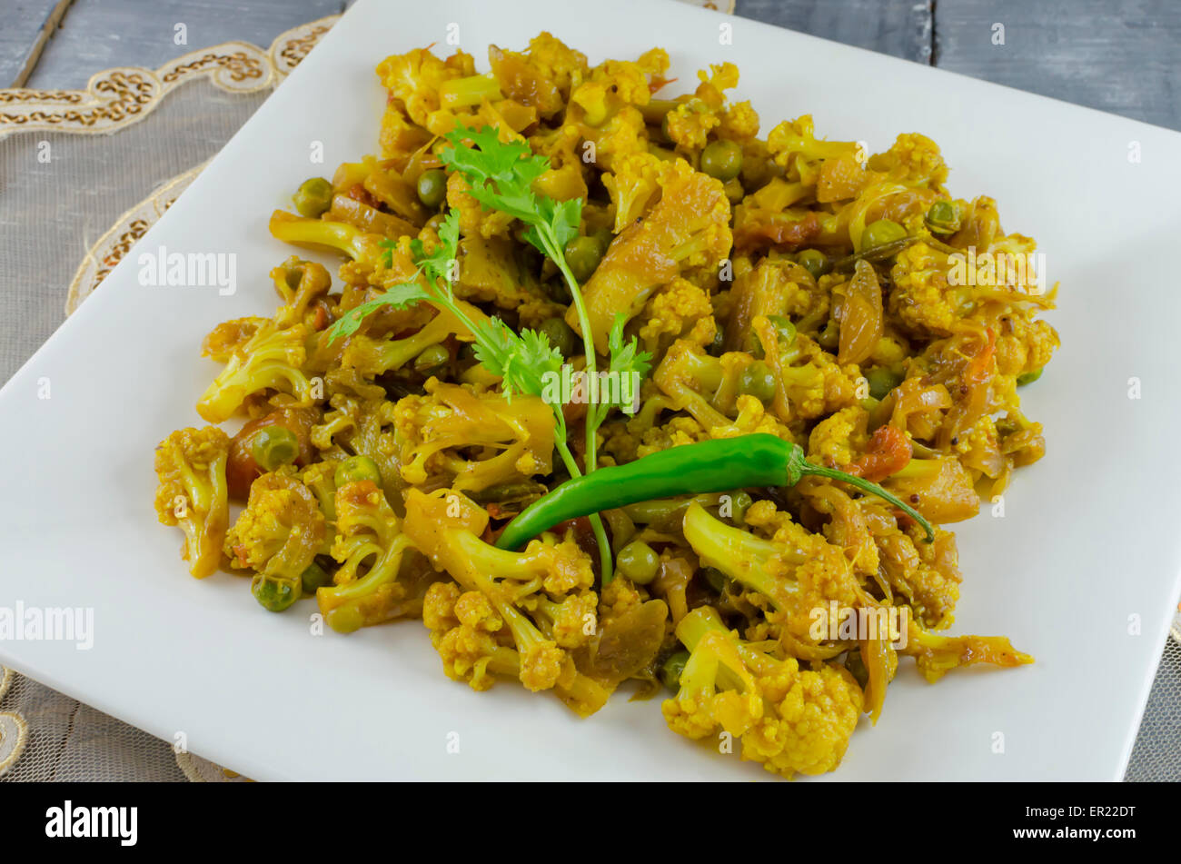 cauliflower florets cooked with green peas and spices Stock Photo - Alamy