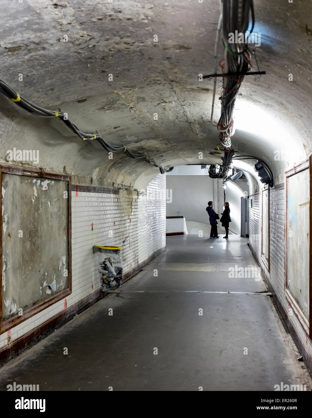Two people talking in dilapidated metro underground railway passage ...