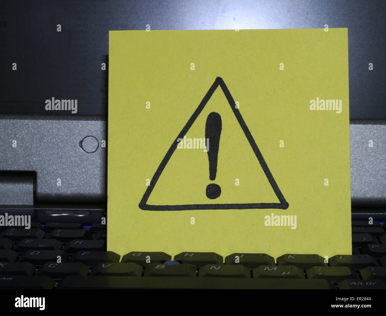 Memo note on notebook, danger exclamation mark in triangle drawing ...