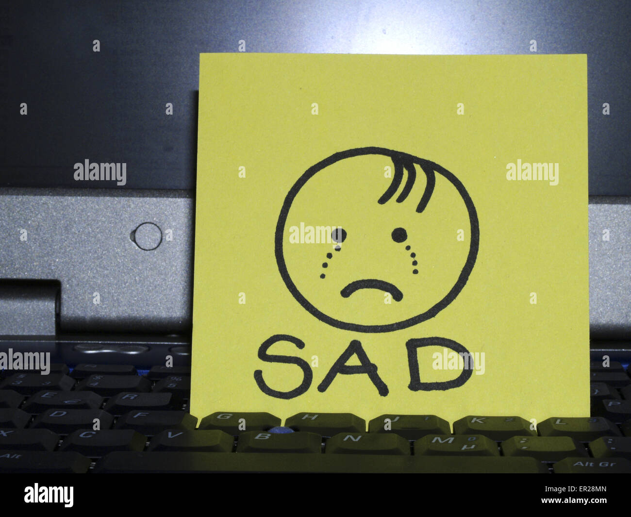 Memo note on notebook, drawing crying face sad Stock Photo - Alamy