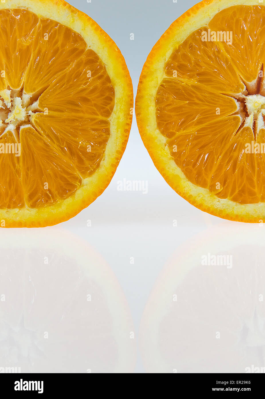 Two halves of an orange on the white and grey gradient background with ...