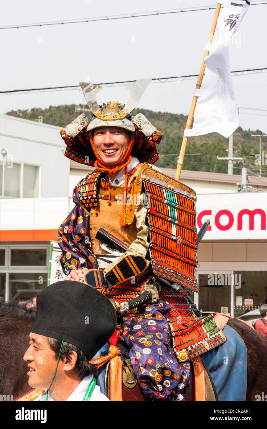 Japanese man dressed in full samurai armour on horseback smiling at ...