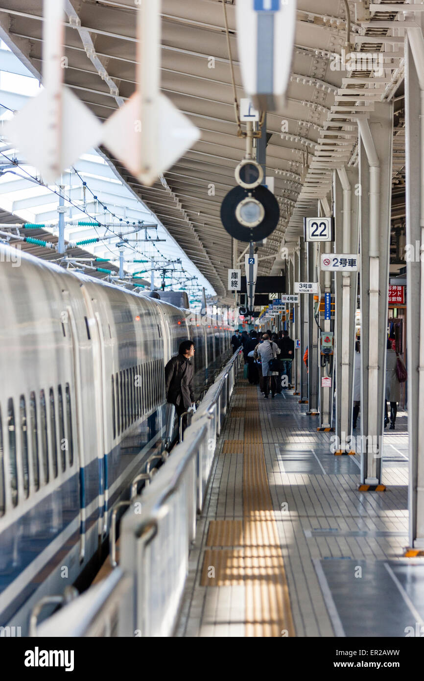 Japanese Shinkansen, bullet train, at platform 22 of Shin Osaka station. View along platform as ...