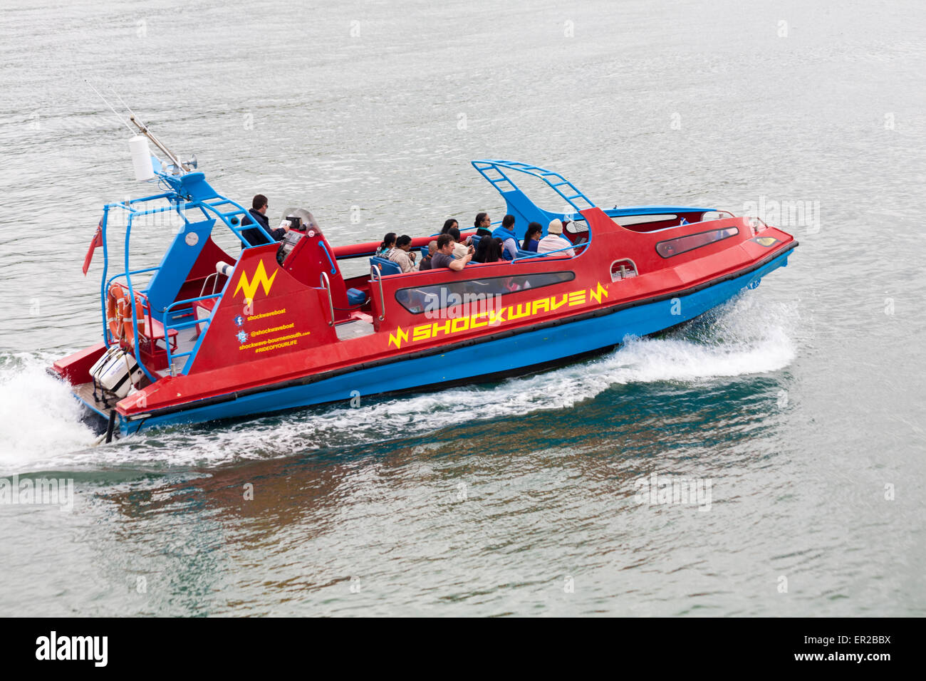 Visitors enjoying a ride on Shockwave boat at Bournemouth Bay, Dorset ...