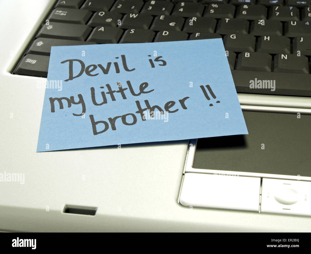 Memo note on notebook, devil is my little brother Stock Photo - Alamy
