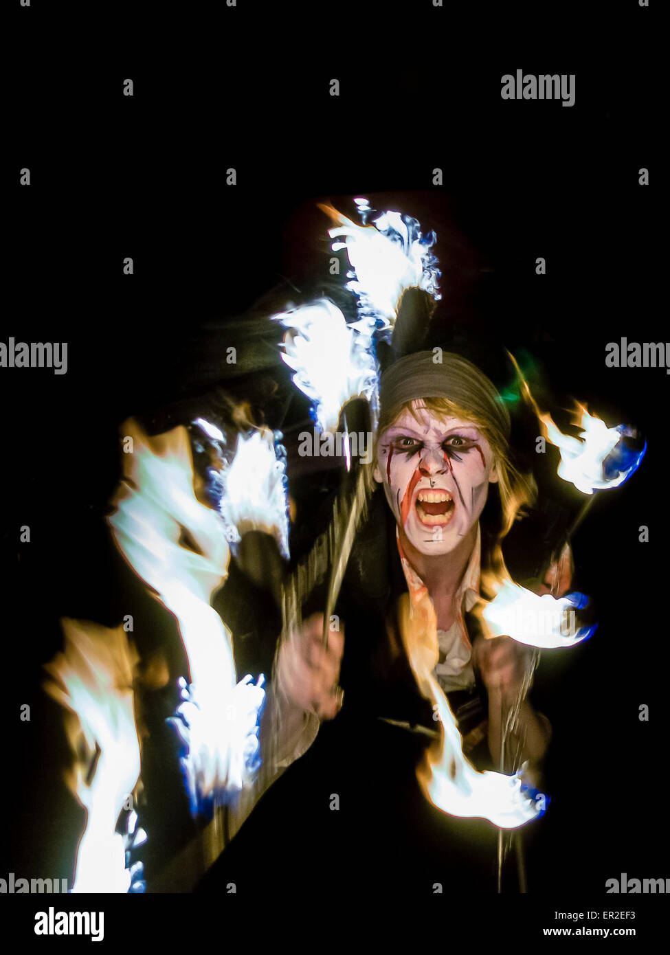 Circus performer with painted face spins torches of fire Stock Photo ...