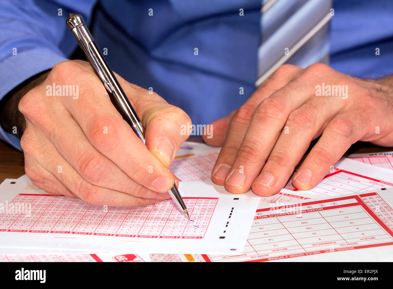 Man Marking on lottery ticket with a pen Stock Photo - Alamy