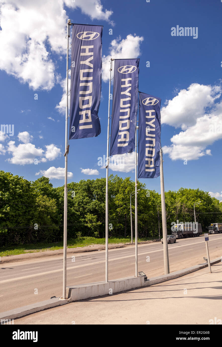 The flags with Hyundai dealership sign over blue sky Stock Photo - Alamy