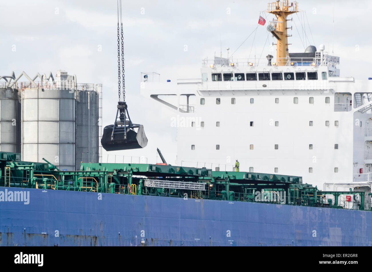 A crane unloads grain cargo from a ship Stock Photo - Alamy