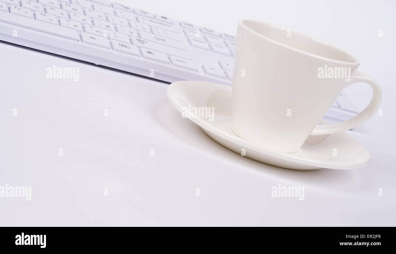 Computer keyboard and cup, side view Stock Photo - Alamy