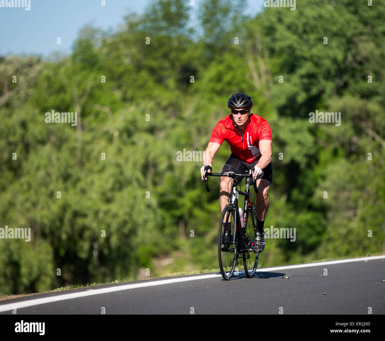 Man riding a road bike on a paved roadway Stock Photo - Alamy